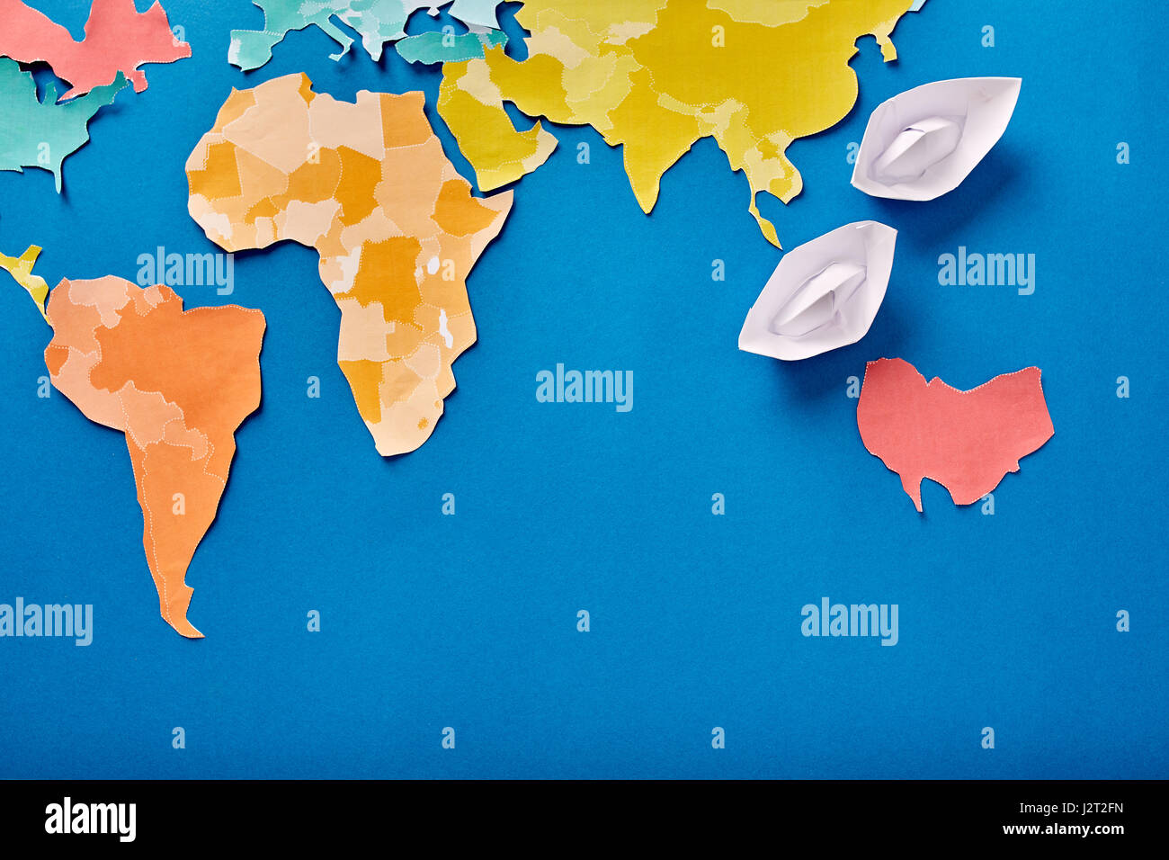 Top view of the white paper boats and international map while cut out ...