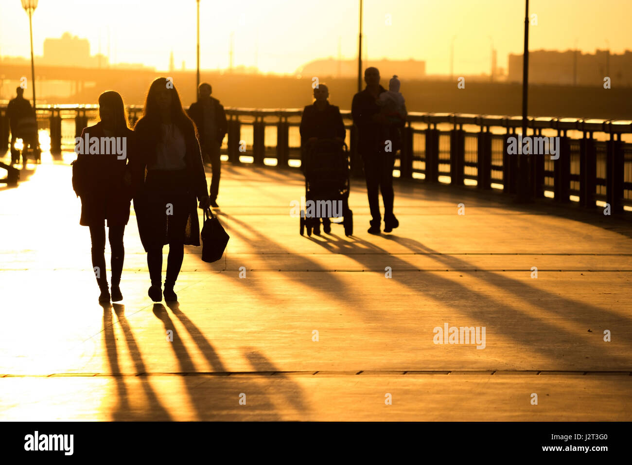 Silhouettes of people walking along the seafront promenade Stock Photo ...