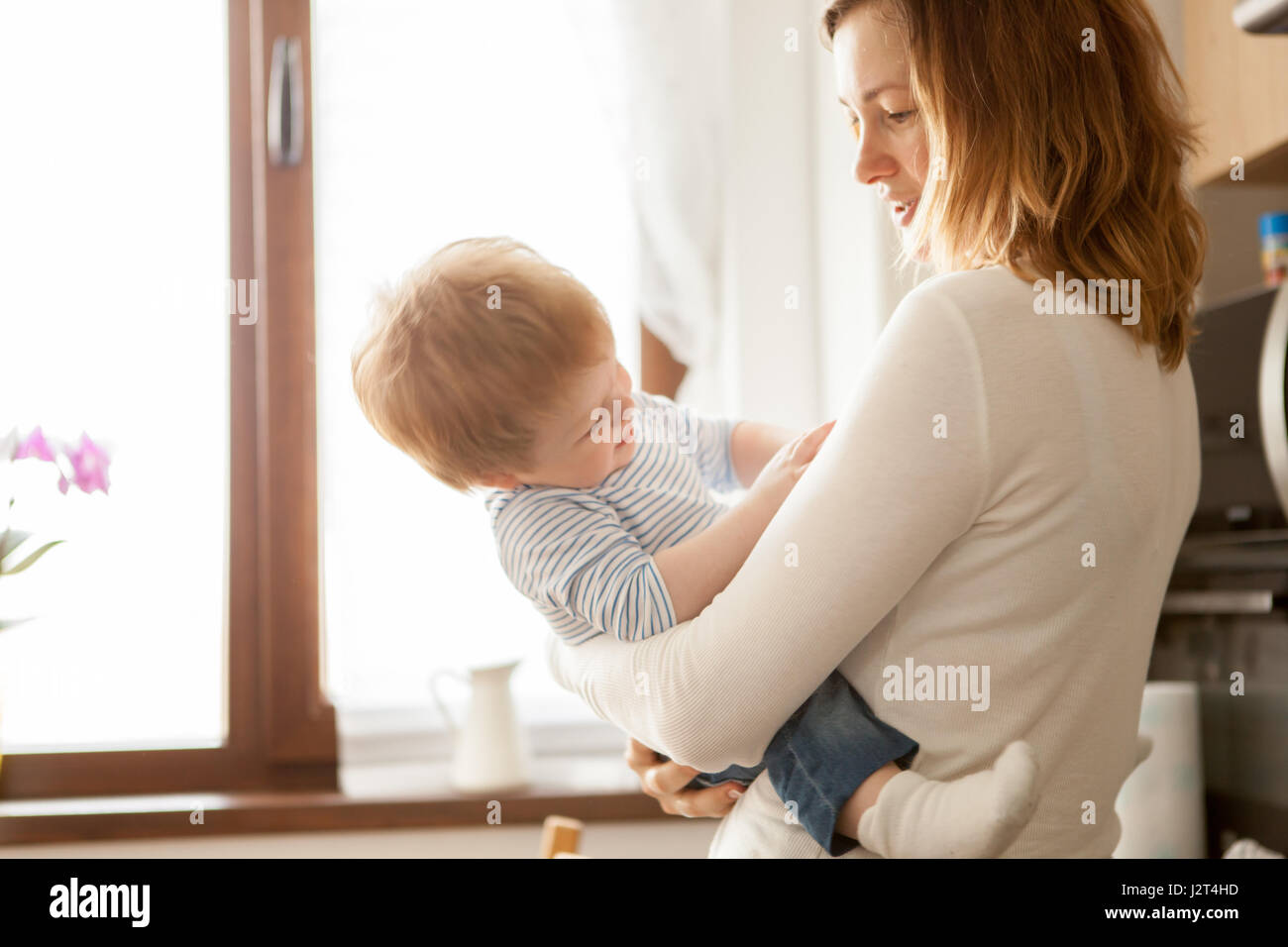 Mother holding her son in arms Stock Photo - Alamy