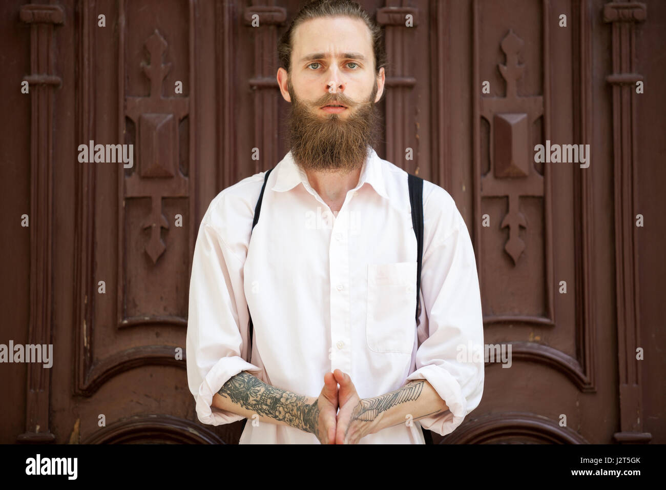 Portrait of bearded hipster in front of a door Stock Photo - Alamy