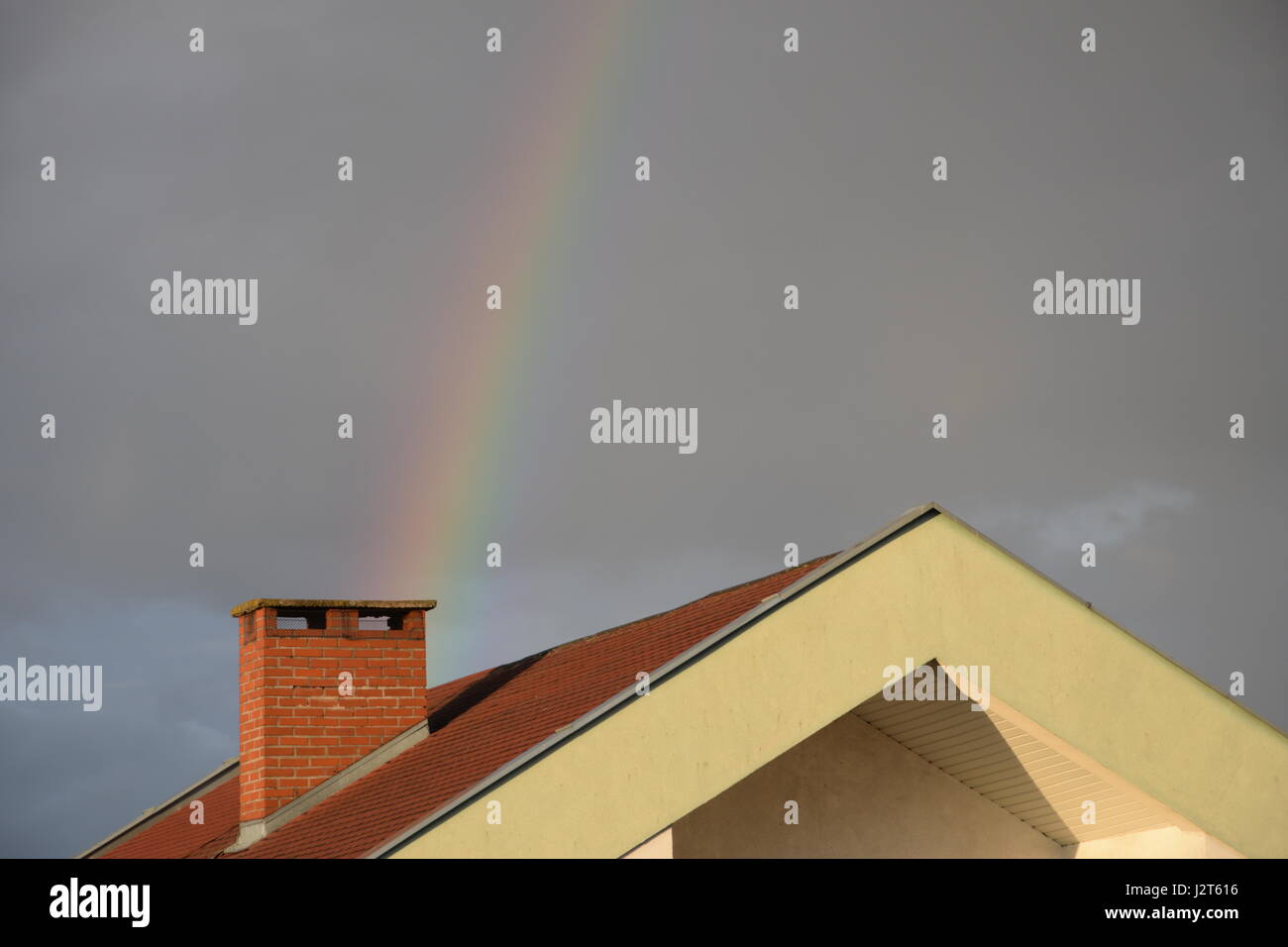 Rainbow over house roof Stock Photo - Alamy