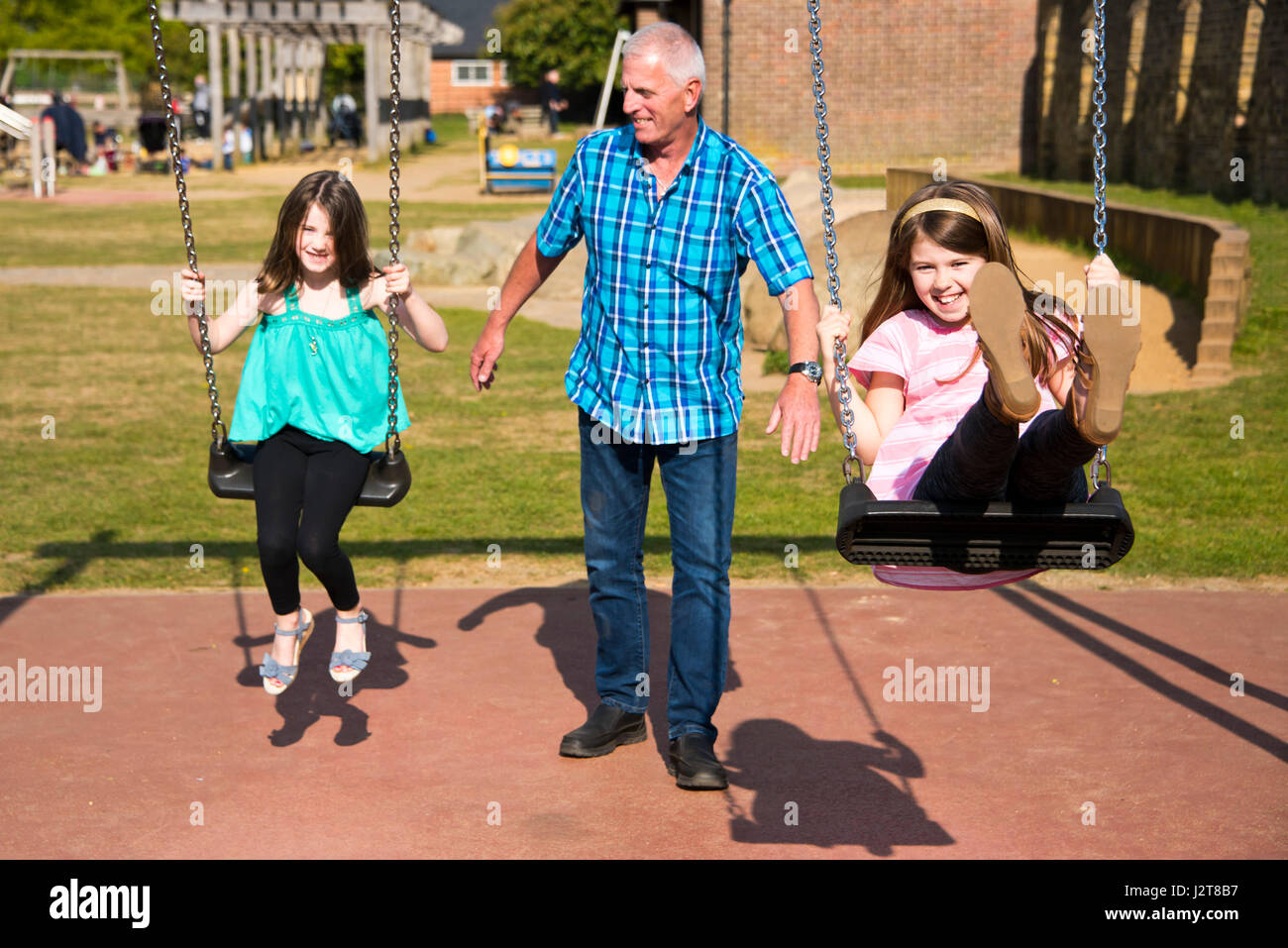 Kids on swing pushing hi-res stock photography and images - Alamy