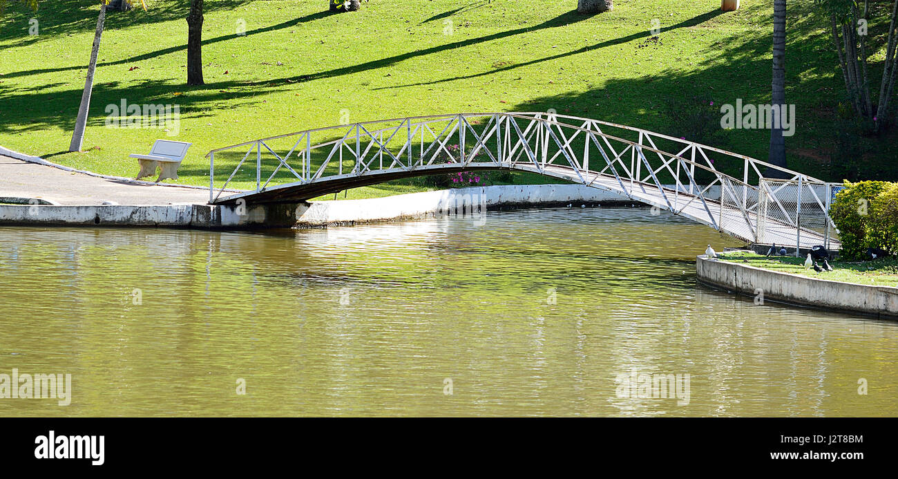 An arched bridge over the water pond in a park on a sunny day Stock ...