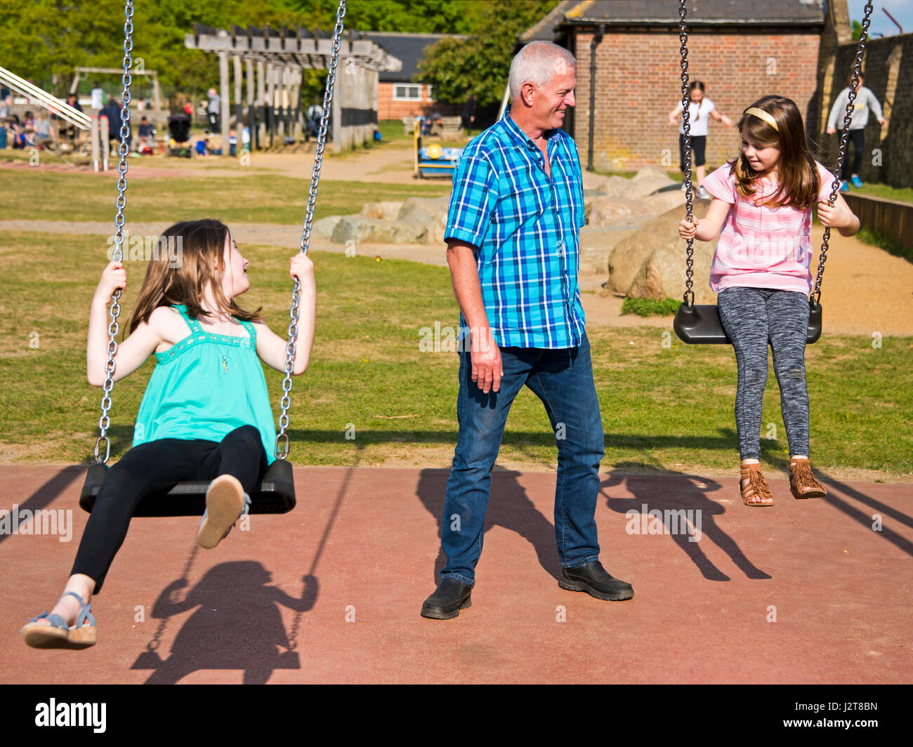 Kids on swing pushing hi-res stock photography and images - Alamy