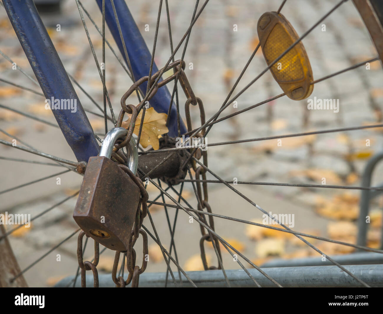 Rusty padlock with a chain attached to a bicycle wheel Stock Photo - Alamy
