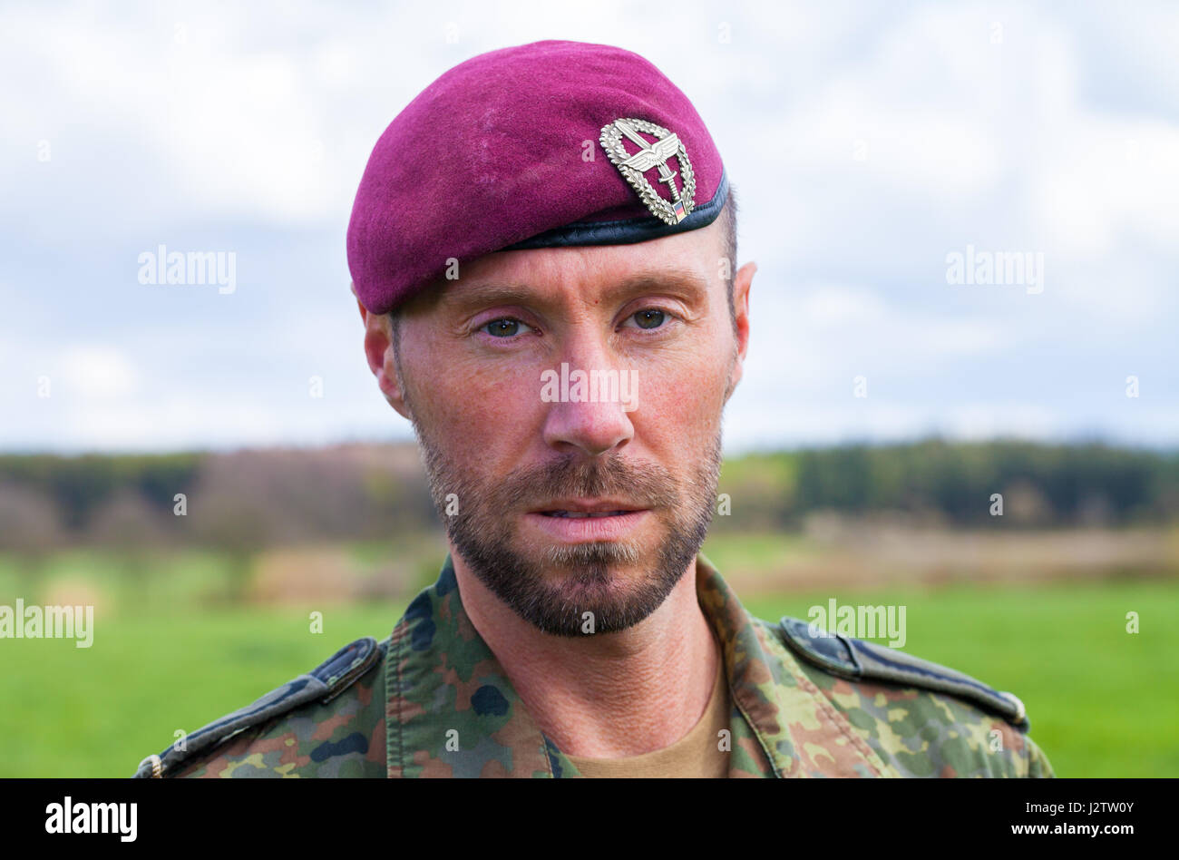 german soldier with a beret stands on a field background Stock Photo ...