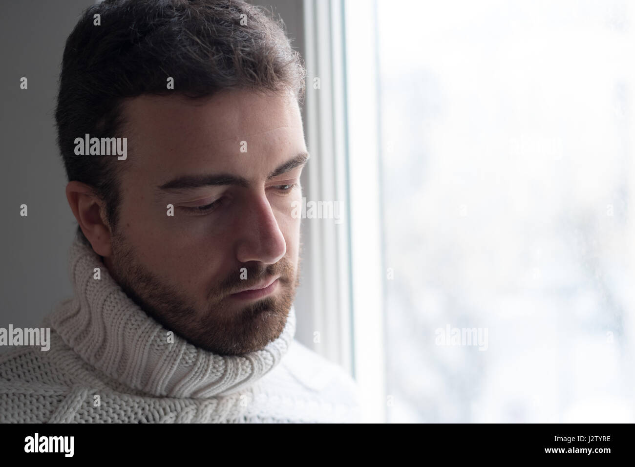 Portrait of sad man looking out of the window Stock Photo - Alamy