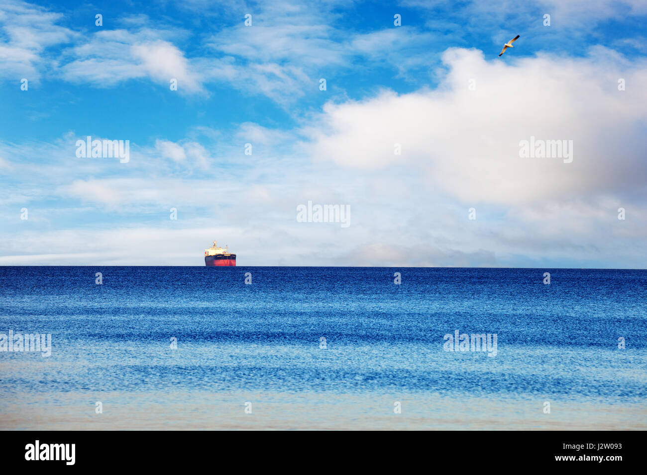 A cargo ship floating on a calm sea Stock Photo - Alamy