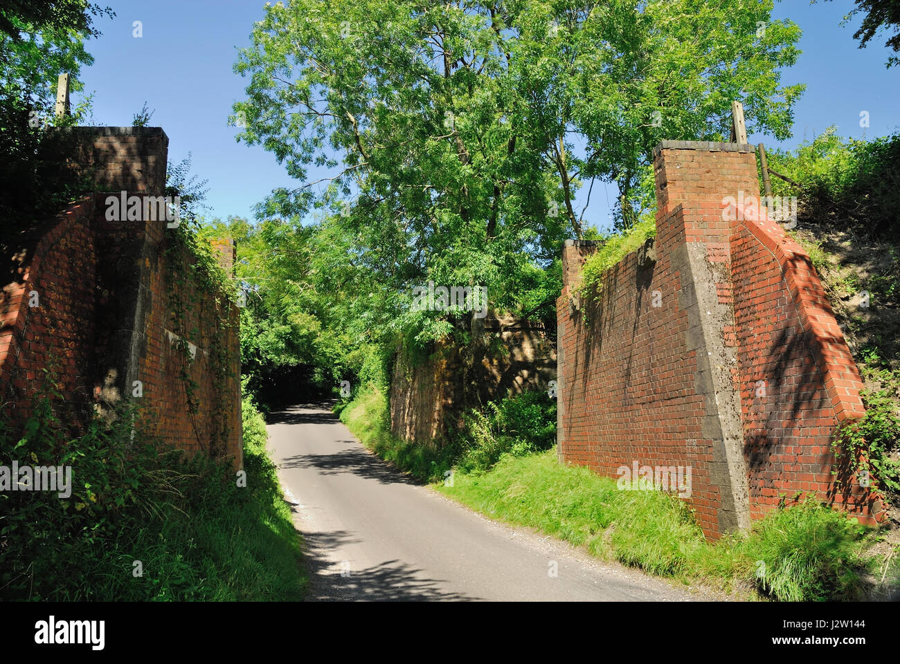 The supporting walls of two former railway bridges over a minor road ...