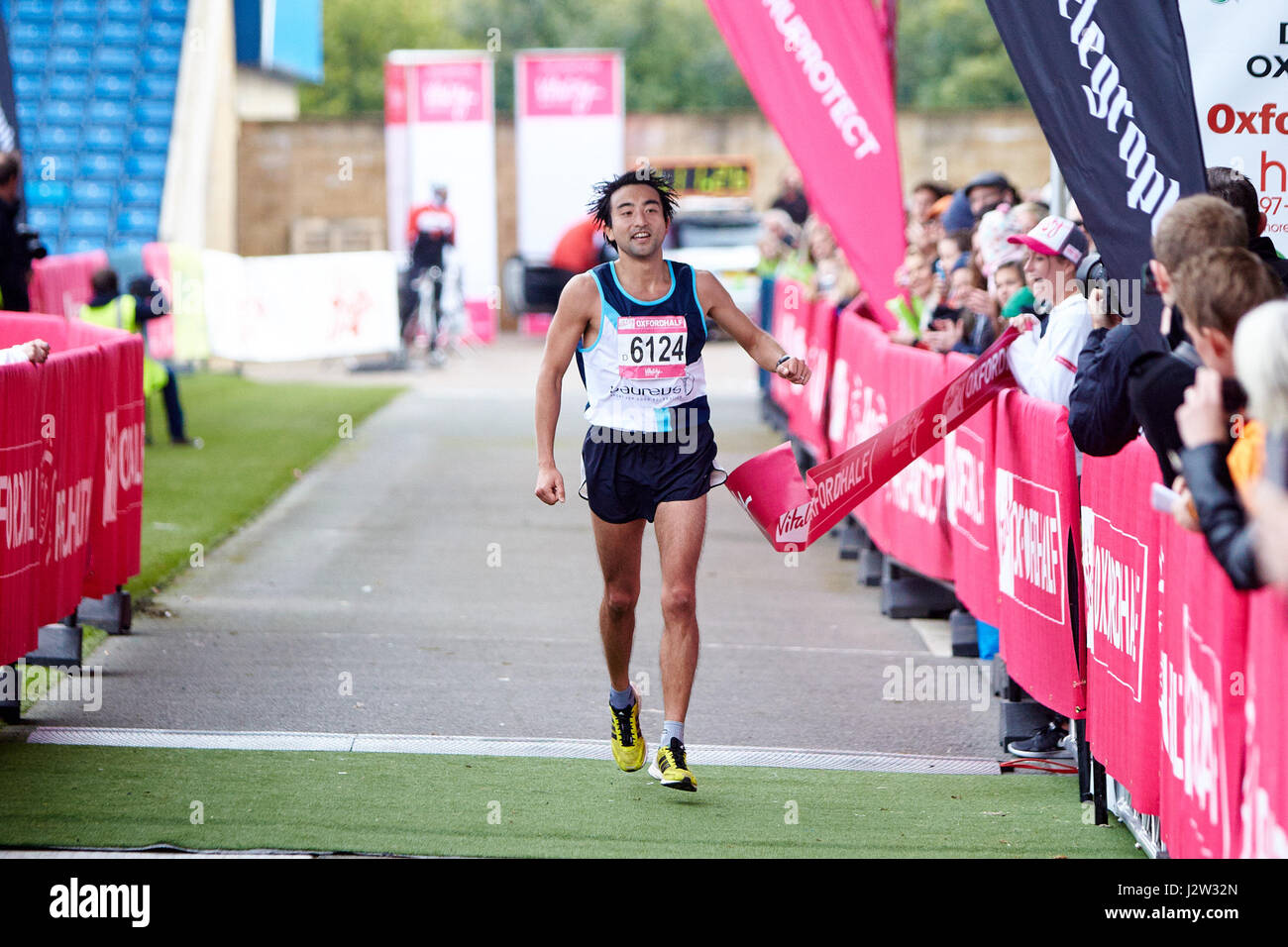 A runner crosses the finish line to win the 2014 Oxford Half Marathon ...
