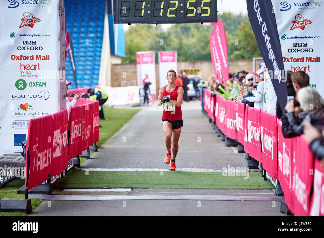 A runner crosses the finish line of the 2014 Oxford Half Marathon to ...