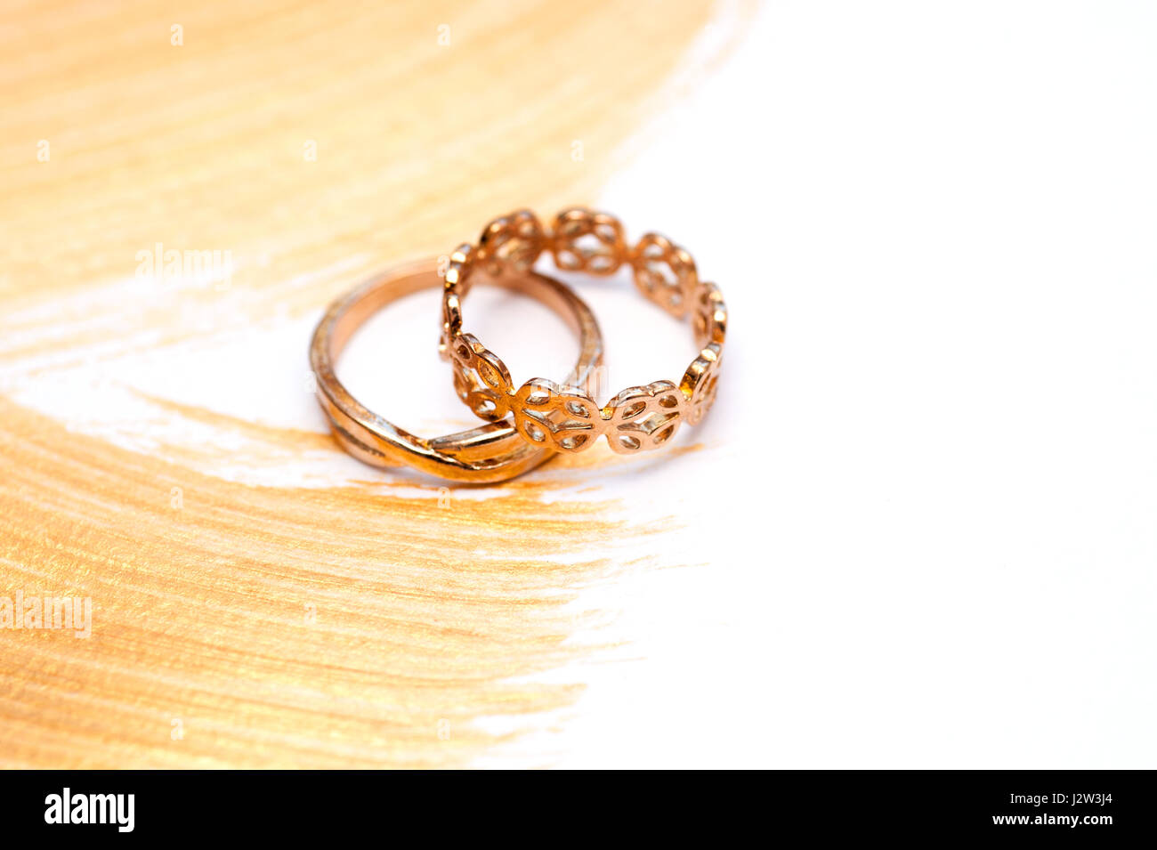 Two gold wedding rings on an abstract gilded acrylic background Stock ...