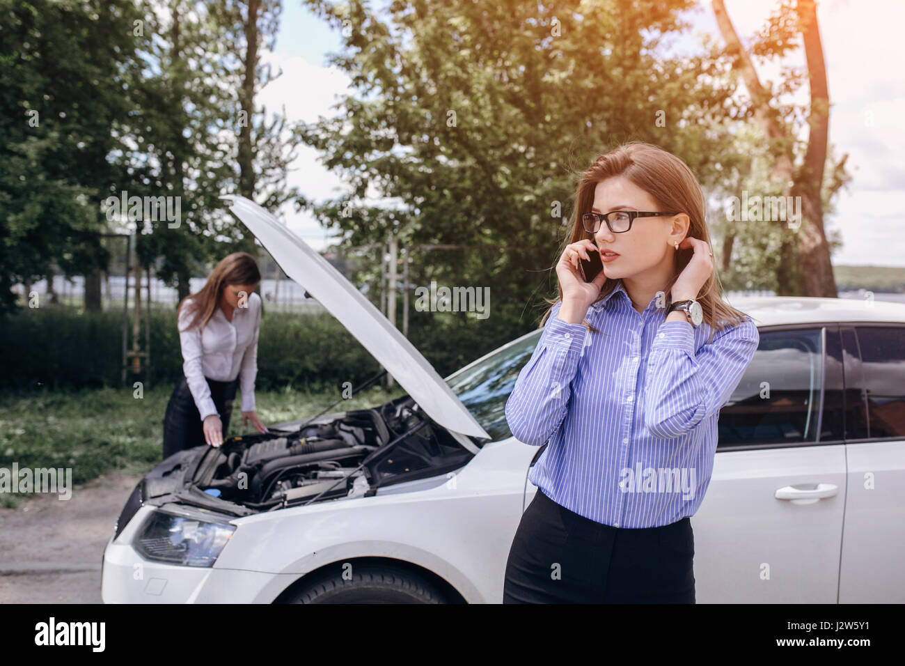 two girls on the road trying to fix their car Stock Photo - Alamy