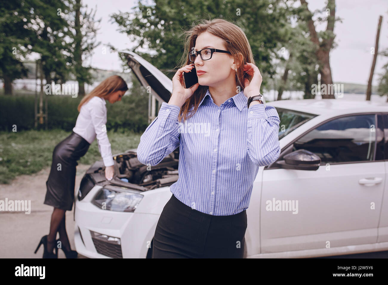 two girls on the road trying to fix their car Stock Photo - Alamy