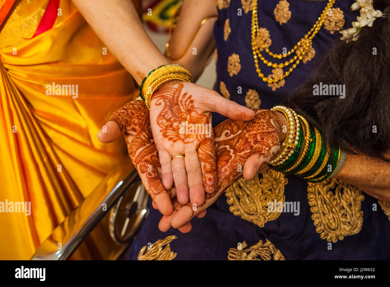 The decorated arms and hands of two women at a Hindu Indian wedding ...