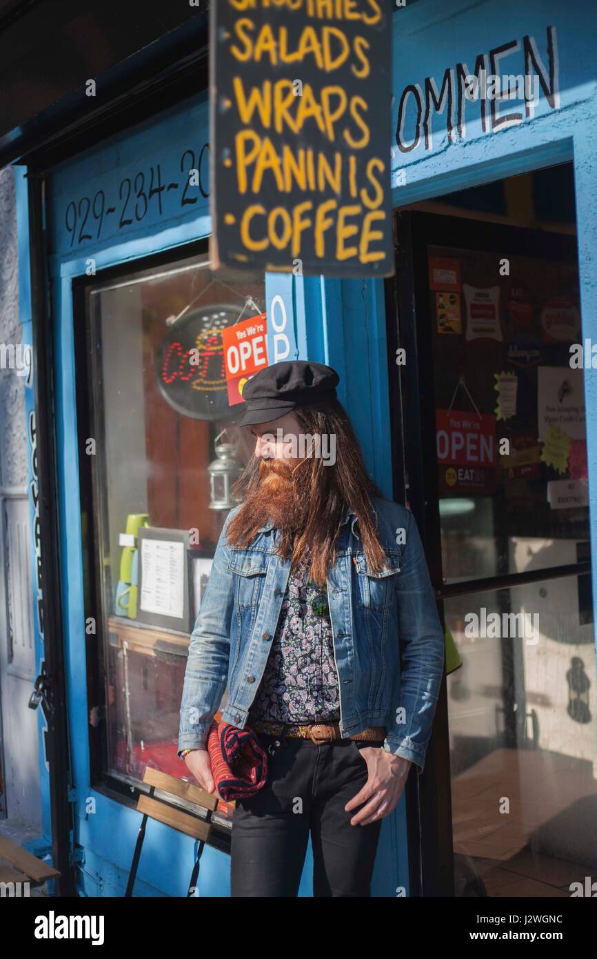 Young man exiting a store Stock Photo - Alamy