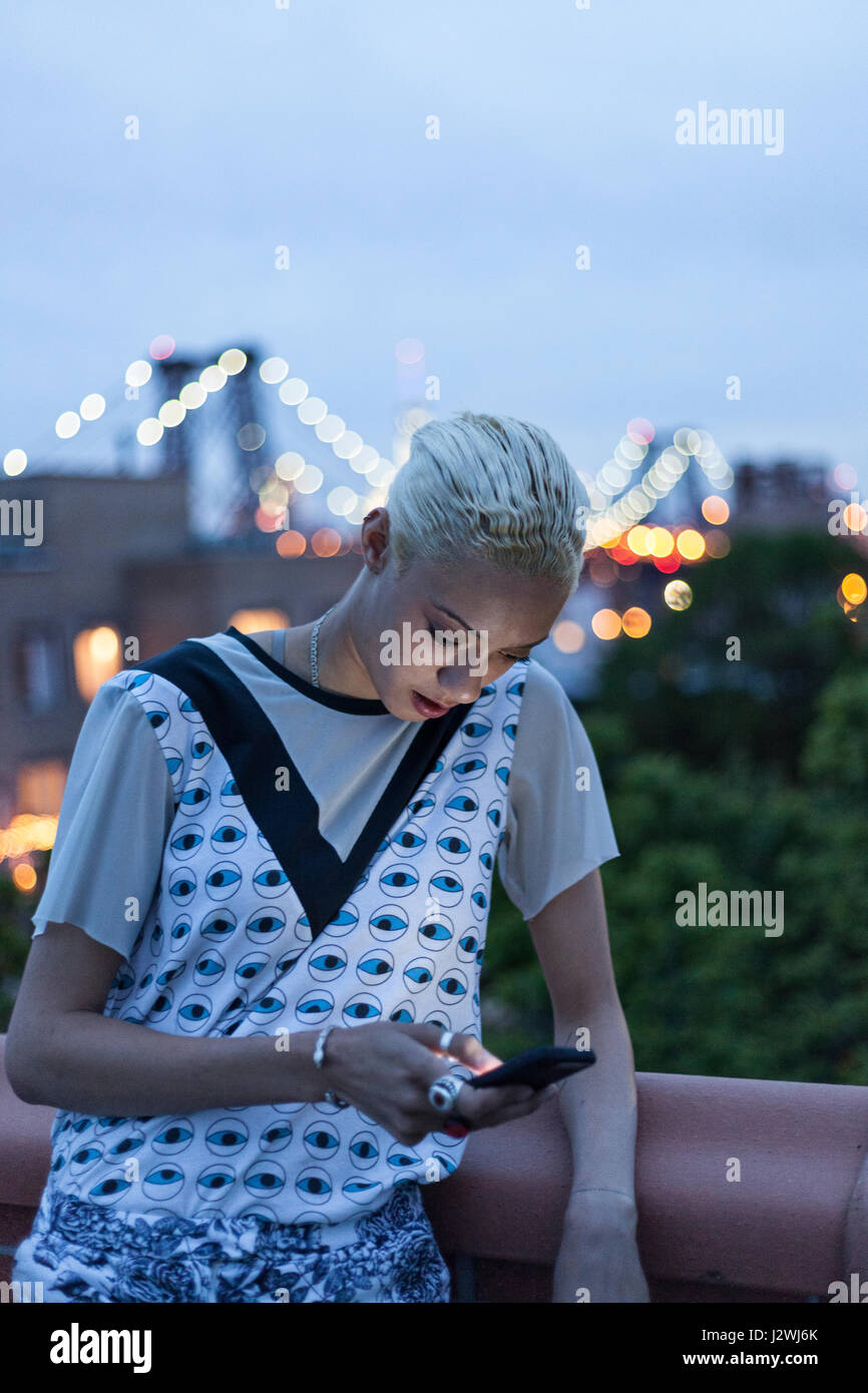 Young woman hanging out on a building rooftop Stock Photo - Alamy