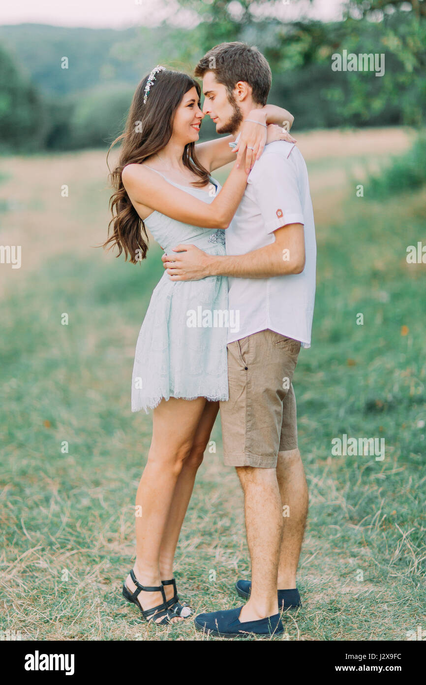 Back view of young embracing couple man and woman hug and look into hi ...