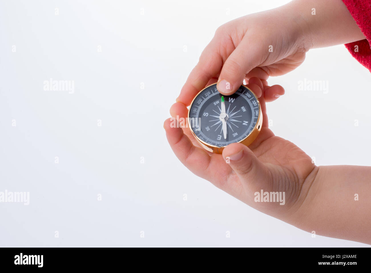 Child hand holding a compass on a white background Stock Photo - Alamy