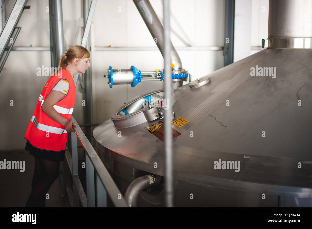 Female worker on beer factory. portrait woman in robe, standing on ...