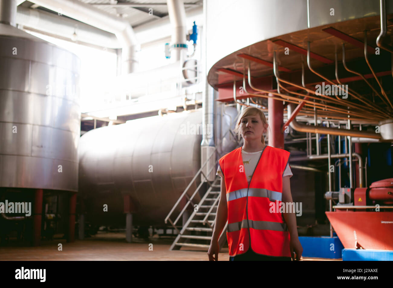 Female worker on beer factory. portrait woman in robe, standing on ...