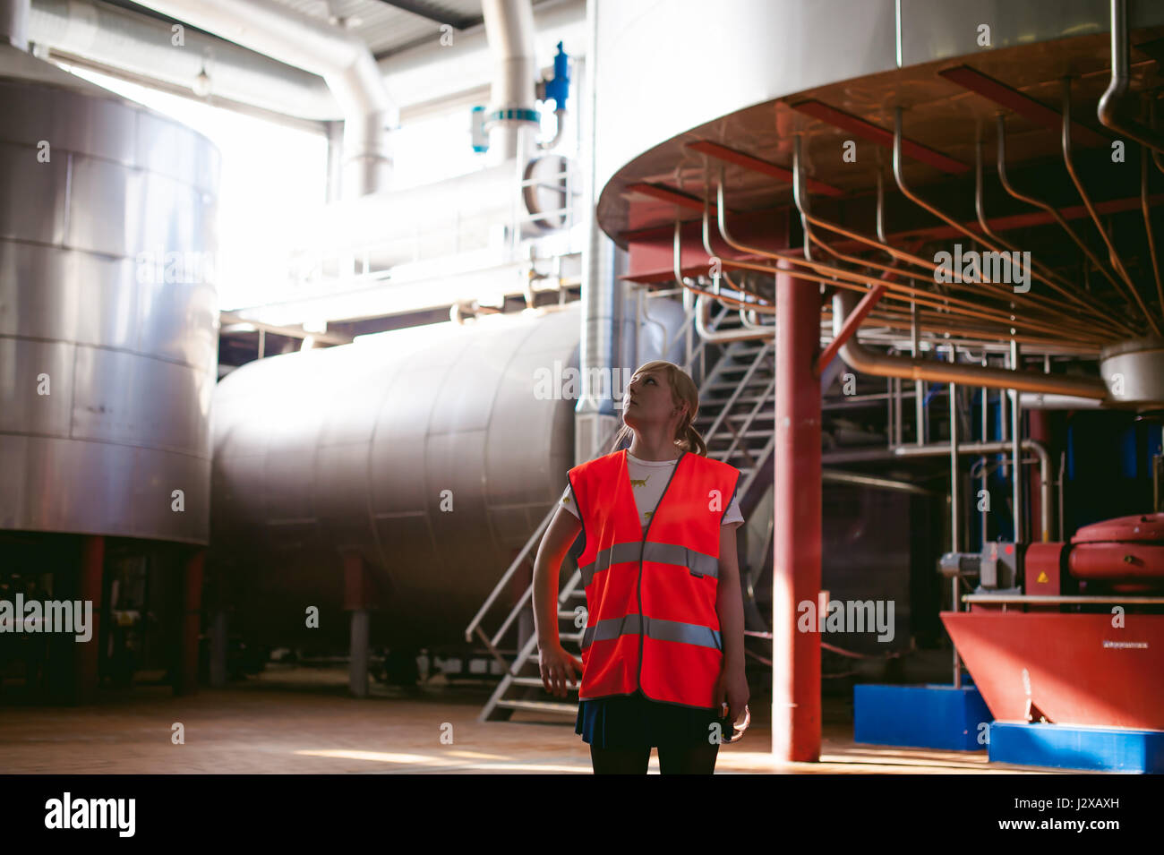 Female worker on beer factory. portrait woman in robe, standing on ...