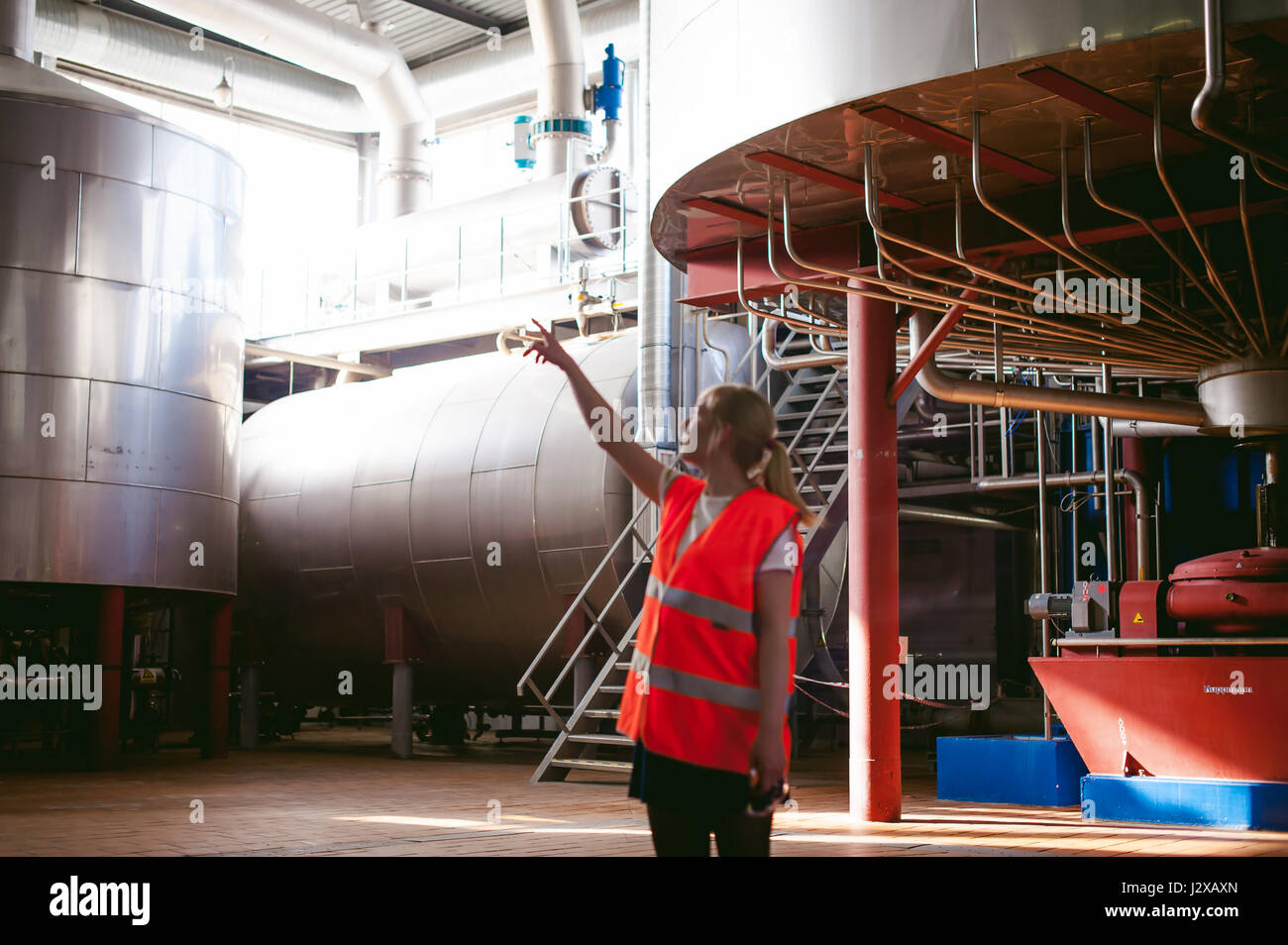 Female worker on beer factory. portrait woman in robe, standing on ...
