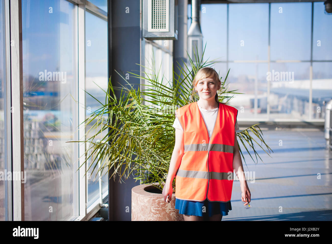 female employee in orange robe wearing vest in working space production ...