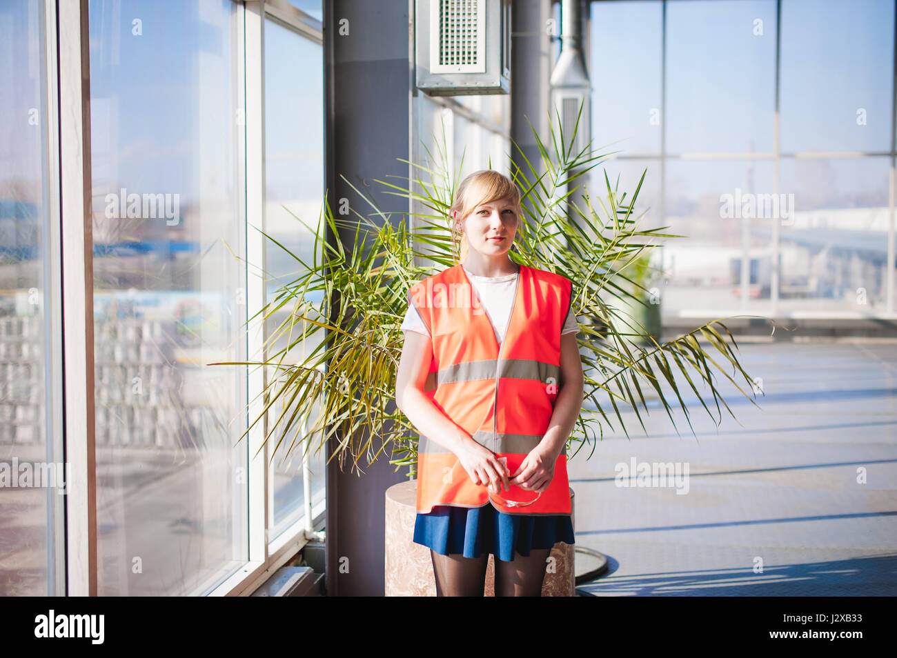 female employee in orange robe wearing vest in working space production ...