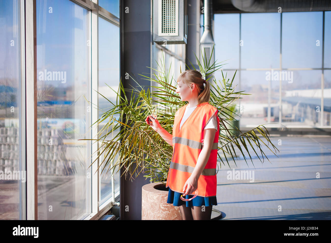 female employee in orange robe wearing vest in working space production ...