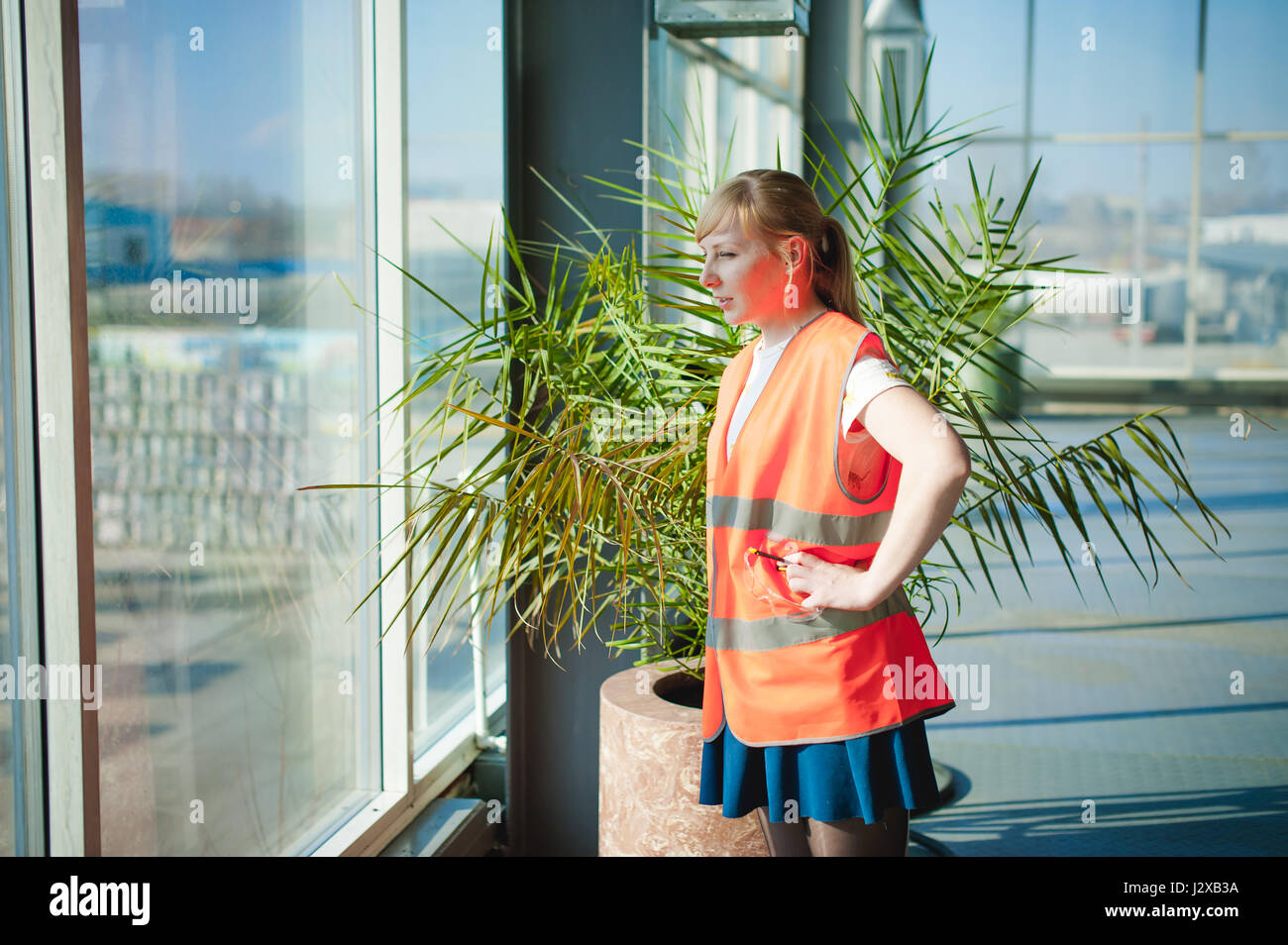 female employee in orange robe wearing vest in working space production ...