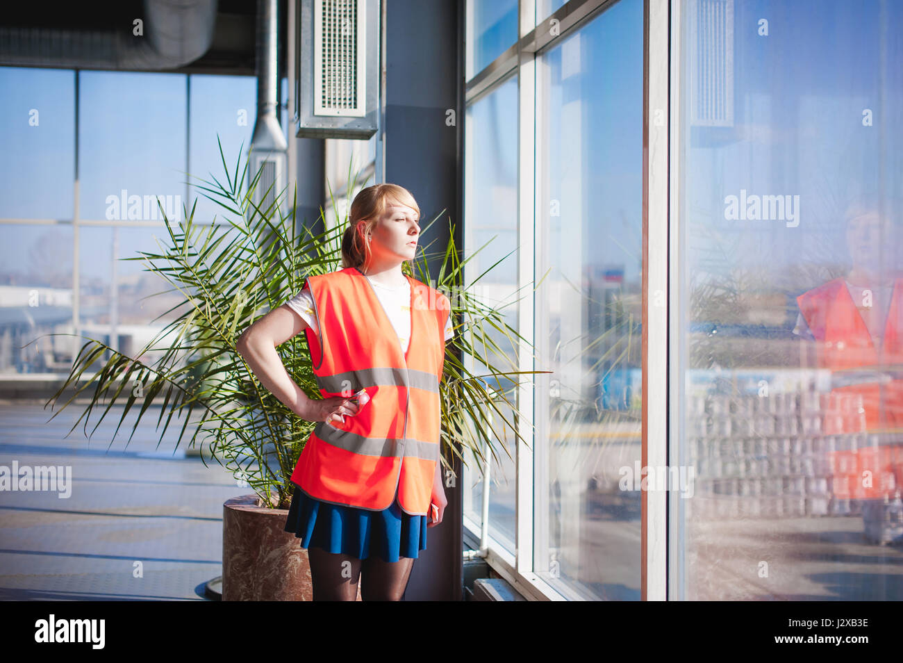 female employee in orange robe wearing vest in working space production ...