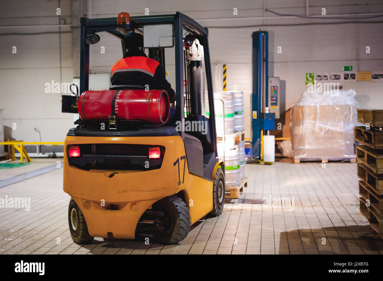 Warehouse employee in Overalls clothes, driver Reachtruck busy working ...