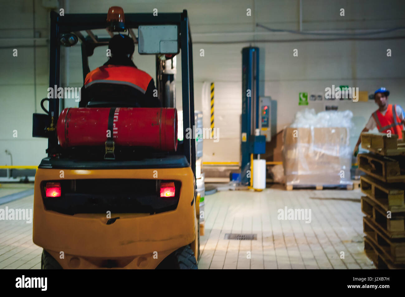 Warehouse employee in Overalls clothes, driver Reachtruck busy working ...