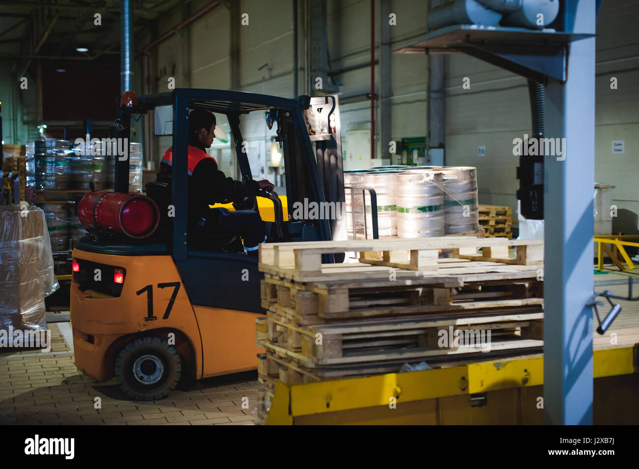 Warehouse employee in Overalls clothes, driver Reachtruck busy working ...