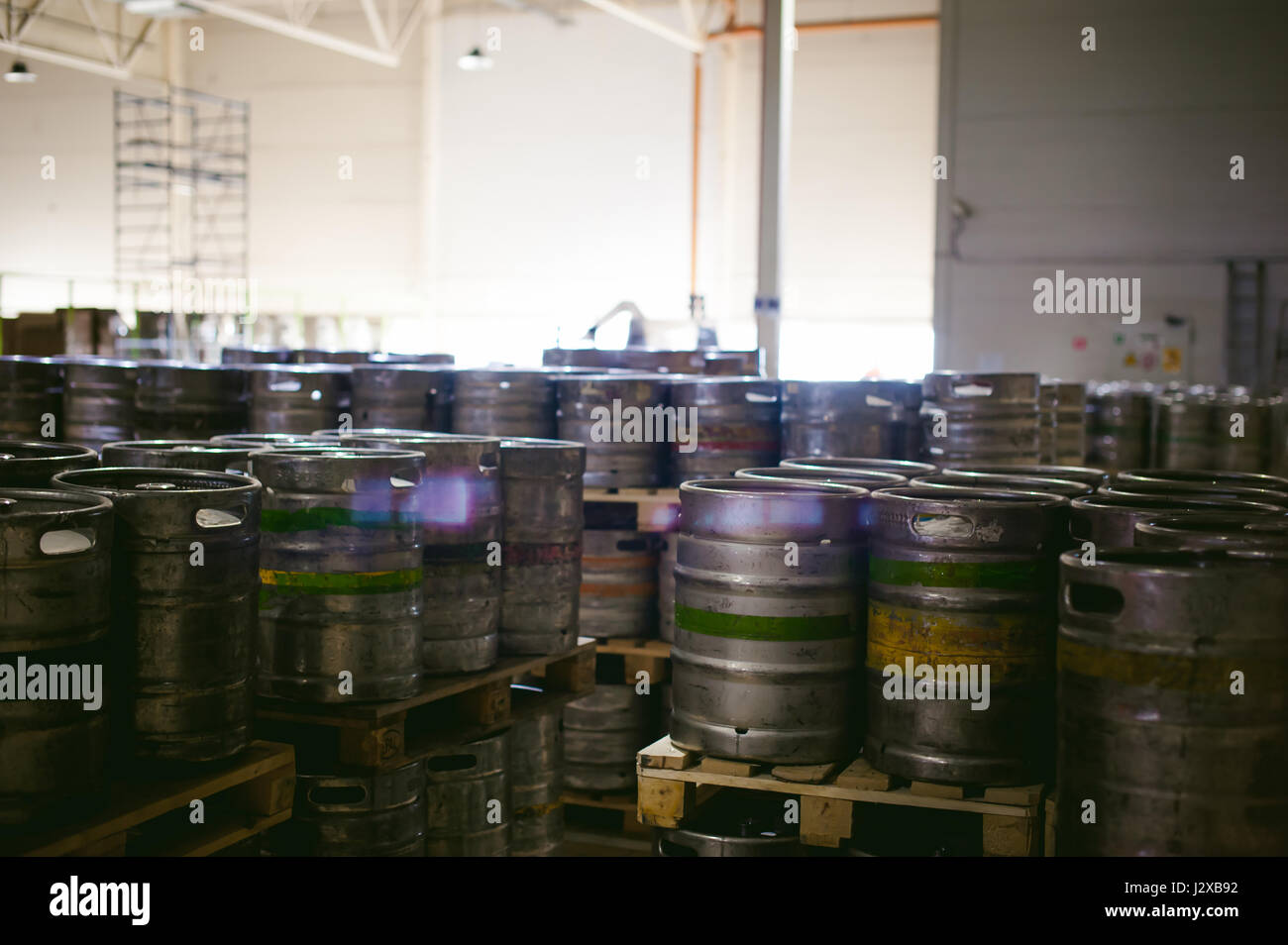 beer kegs. many metal beer keg stand in rows in a warehouse Stock Photo ...
