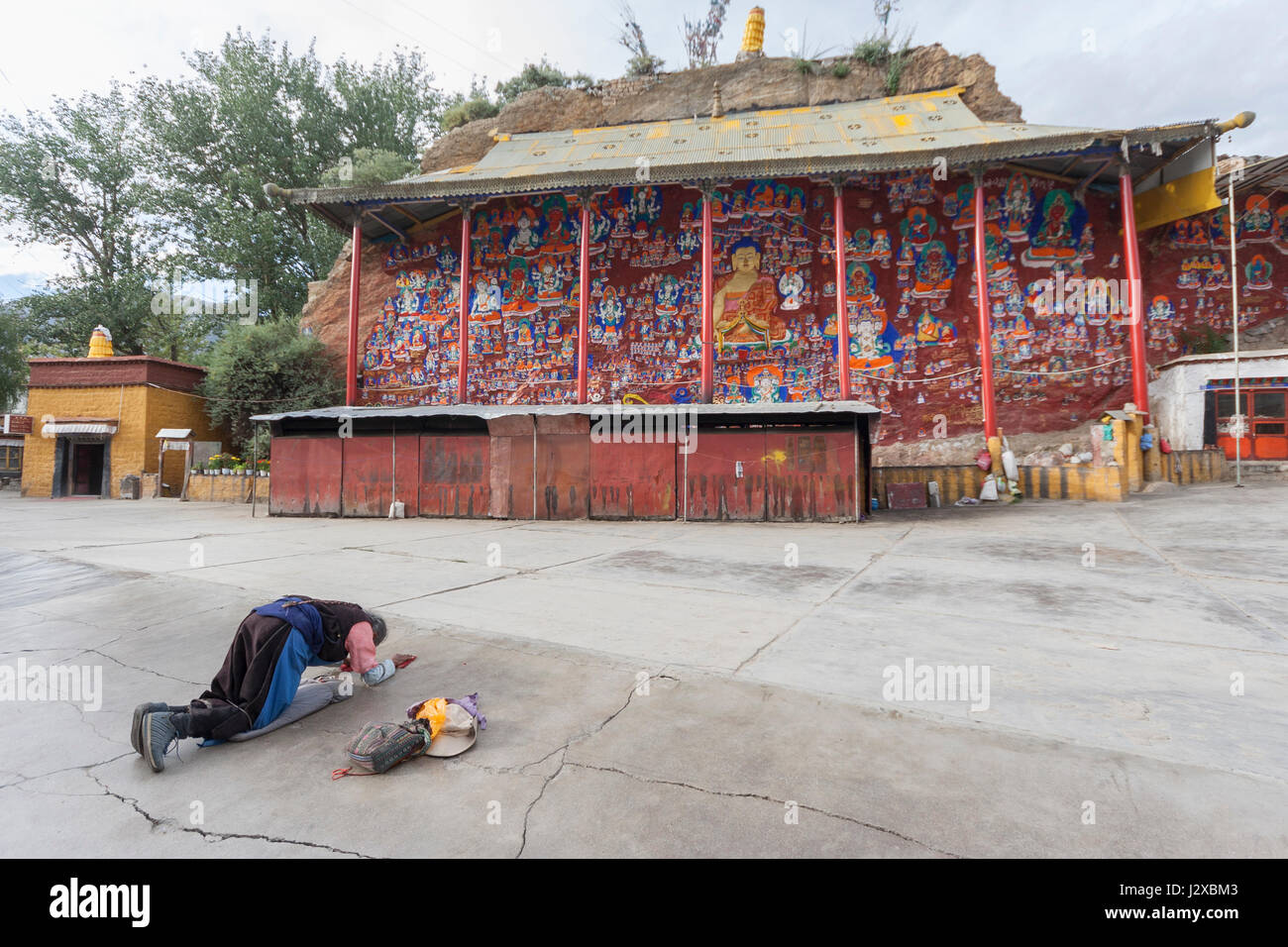Tibetan Buddhist pilgrim performing full body prostrations in front of ...