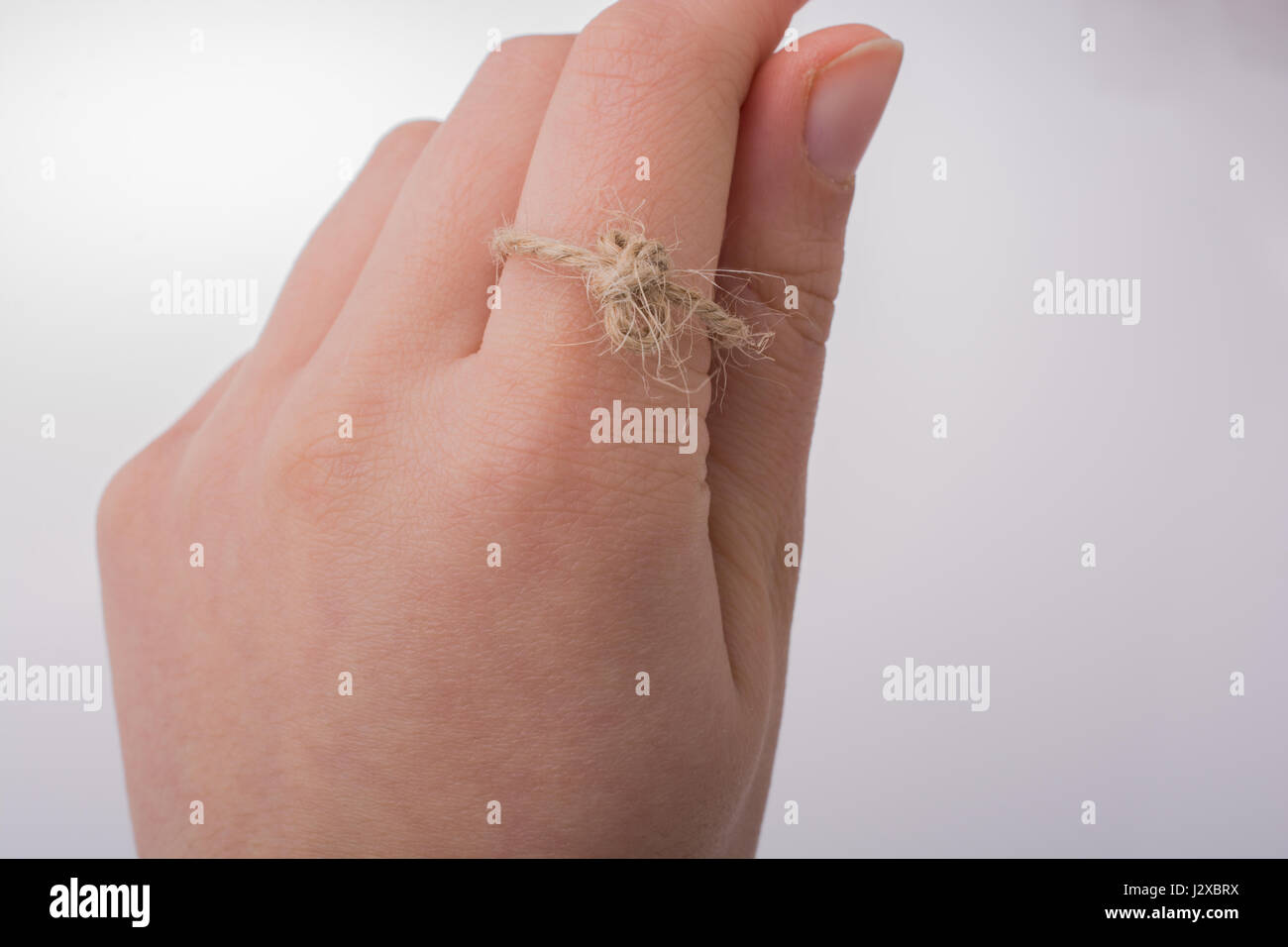 Thread knot in hand on a light color background Stock Photo - Alamy