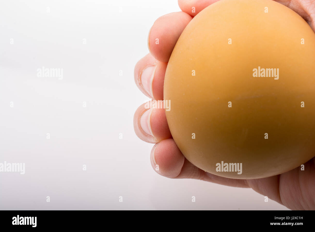 Squeezing yellow balloon with hand on a white background Stock Photo ...