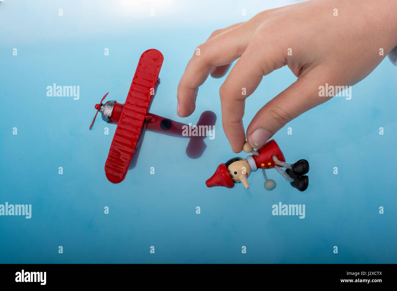 Pinocchio and a model airplane in water Stock Photo - Alamy