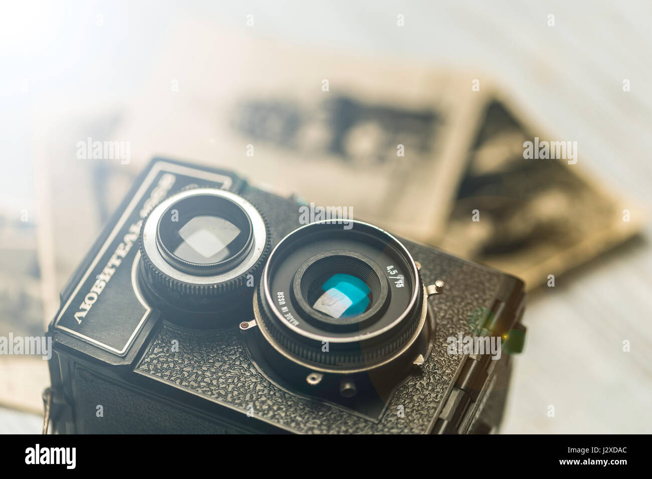 Studio shot of old vintage photo camera with pictures on wooden ...