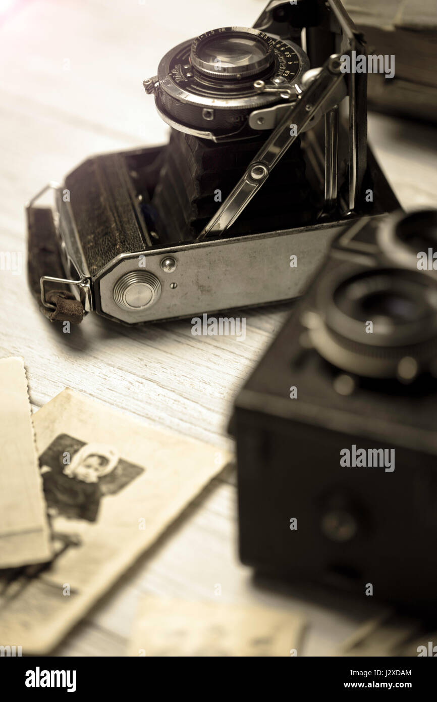 Studio shot of old vintage photo camera with pictures on wooden ...