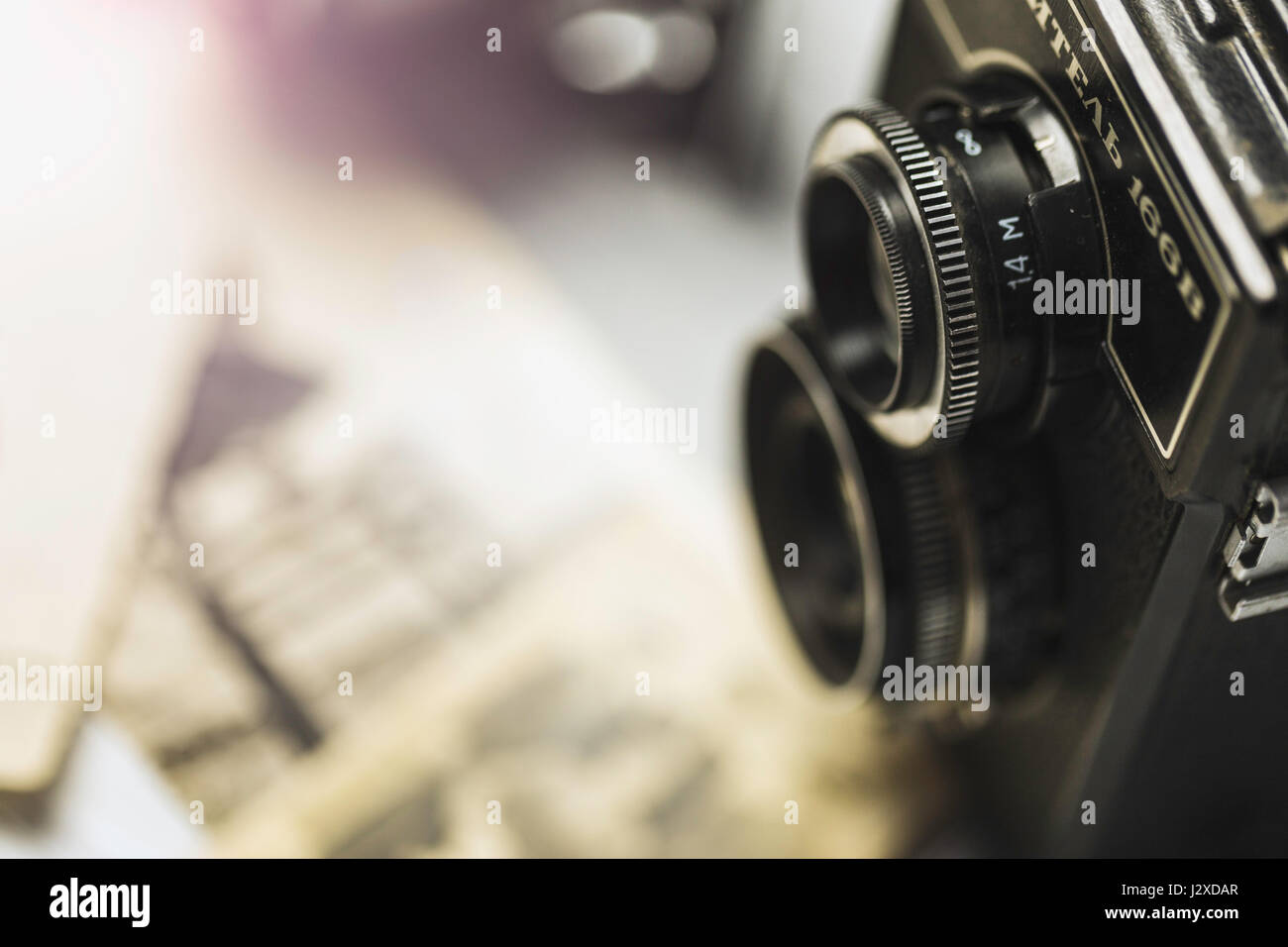 Studio shot of old vintage photo camera with pictures on wooden ...