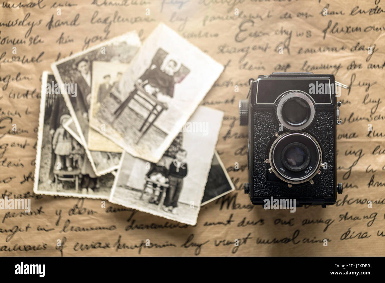 Studio shot of old vintage photo camera with pictures on wooden ...