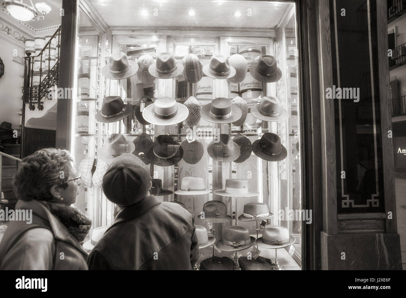 couple in front of window of a traditional hat shop in Seville, Spain ...