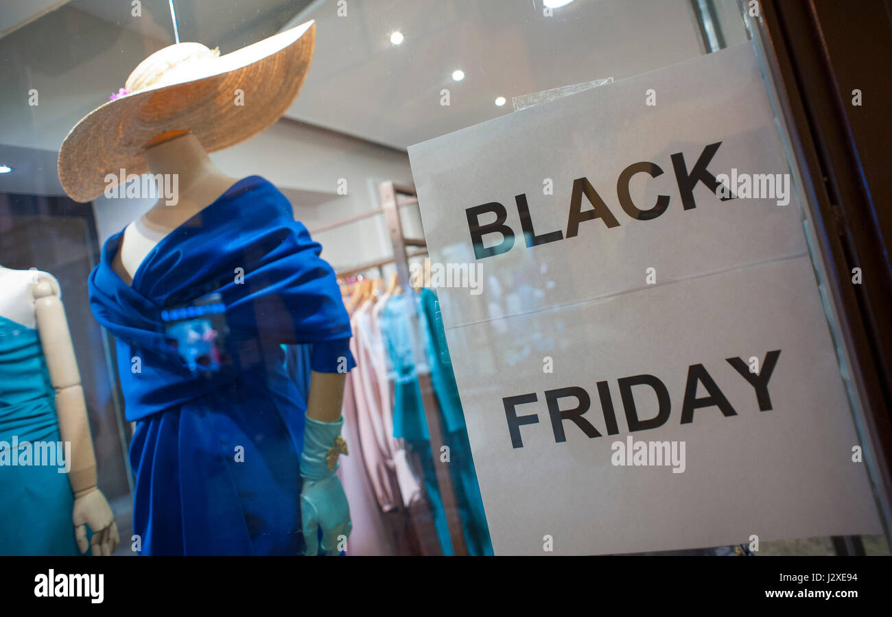 evening dresses in the shop window of fashion boutique with sign ...