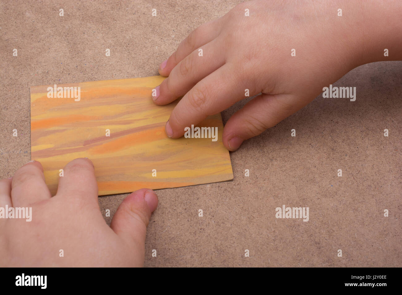 Hand holding painted note paper on brown background Stock Photo - Alamy