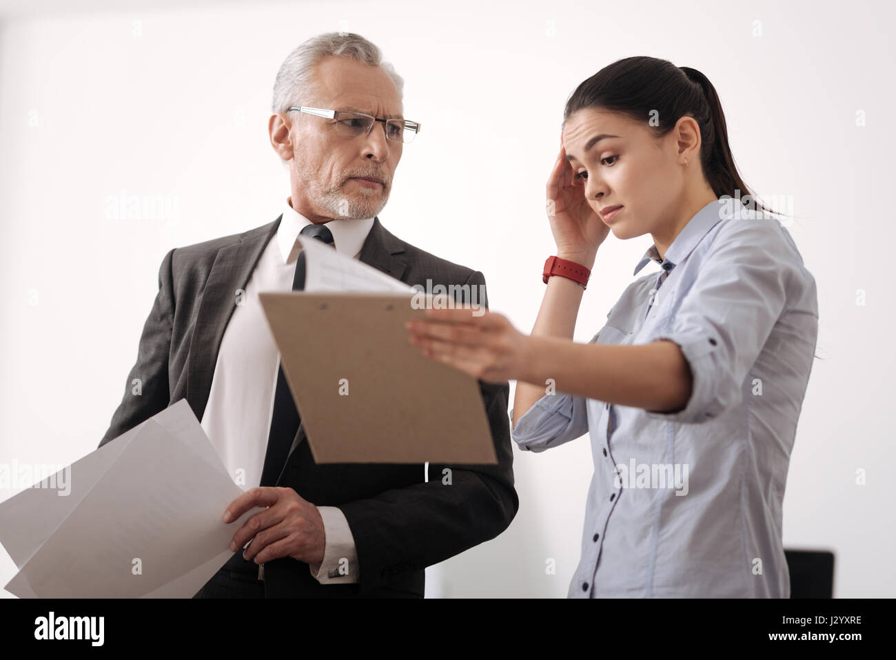 Serious boss standing and looking at his secretary Stock Photo - Alamy