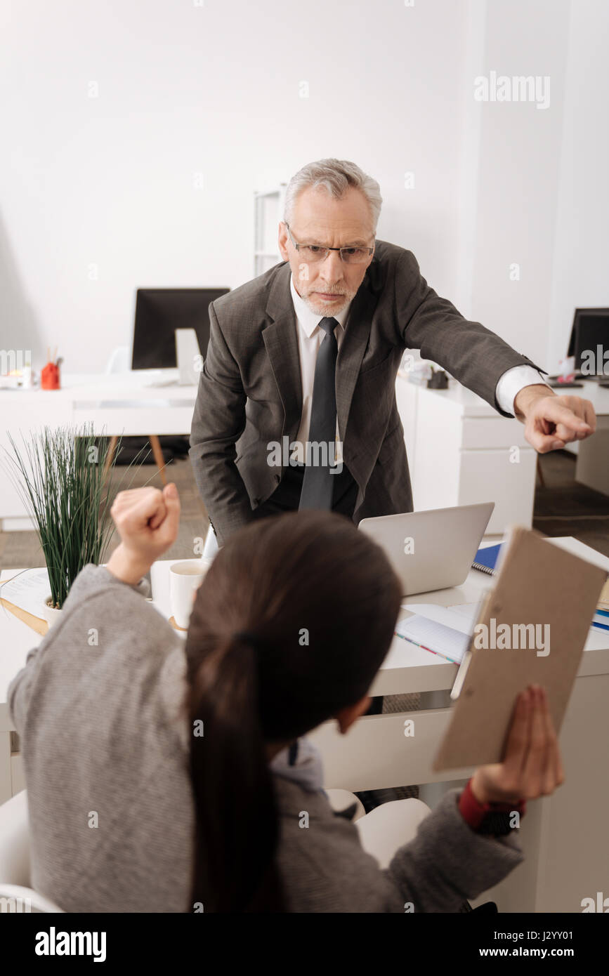 Resolute male person giving the bucket to his worker Stock Photo - Alamy