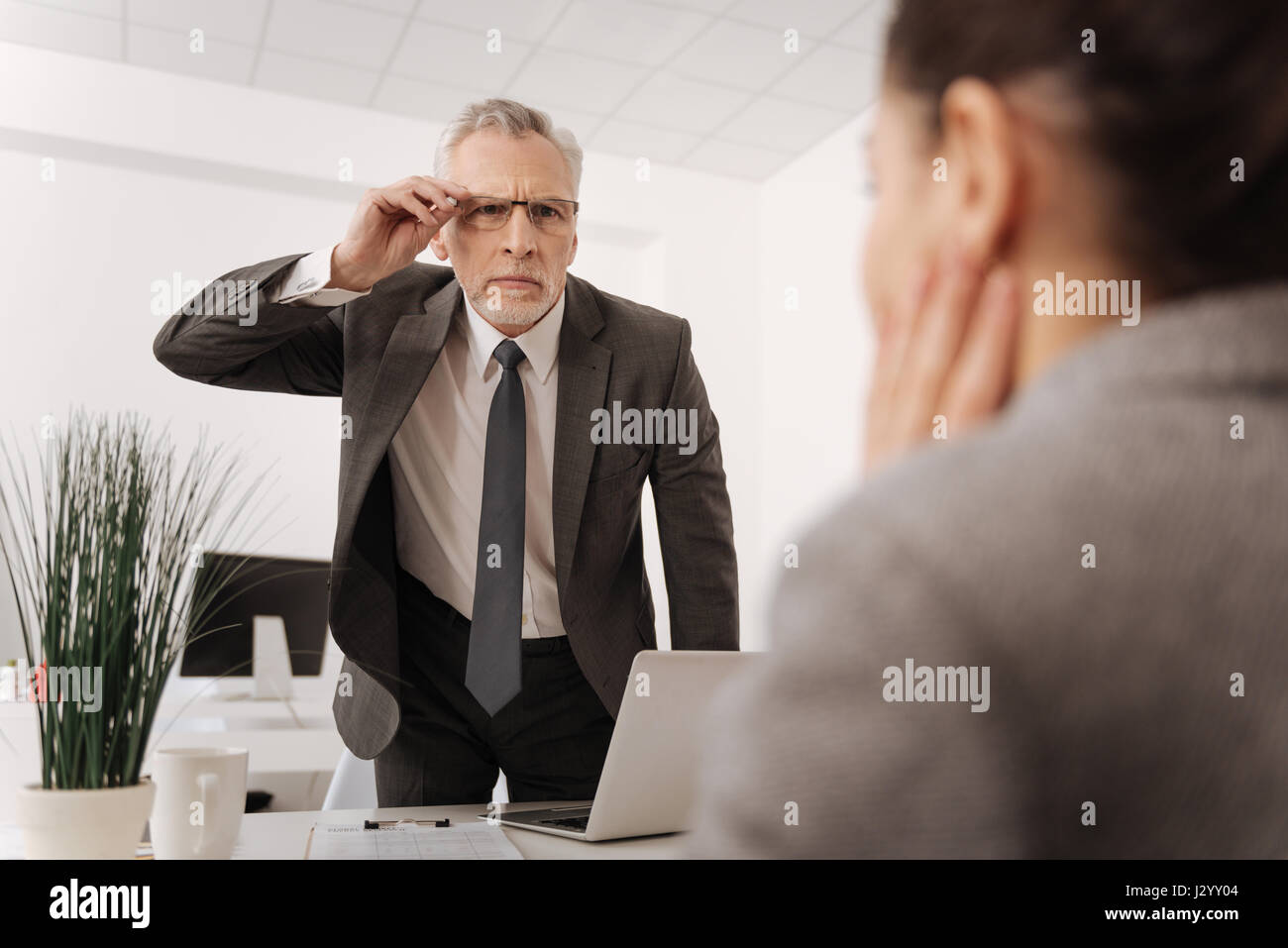 Very attentive office worker narrowing his eyes Stock Photo - Alamy